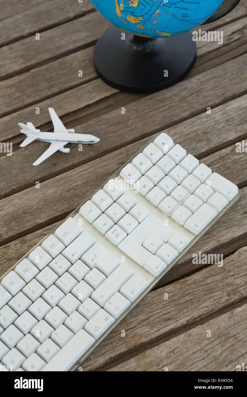 Overhead of globe, airplane model and keyboard on wooden plank Stock ...