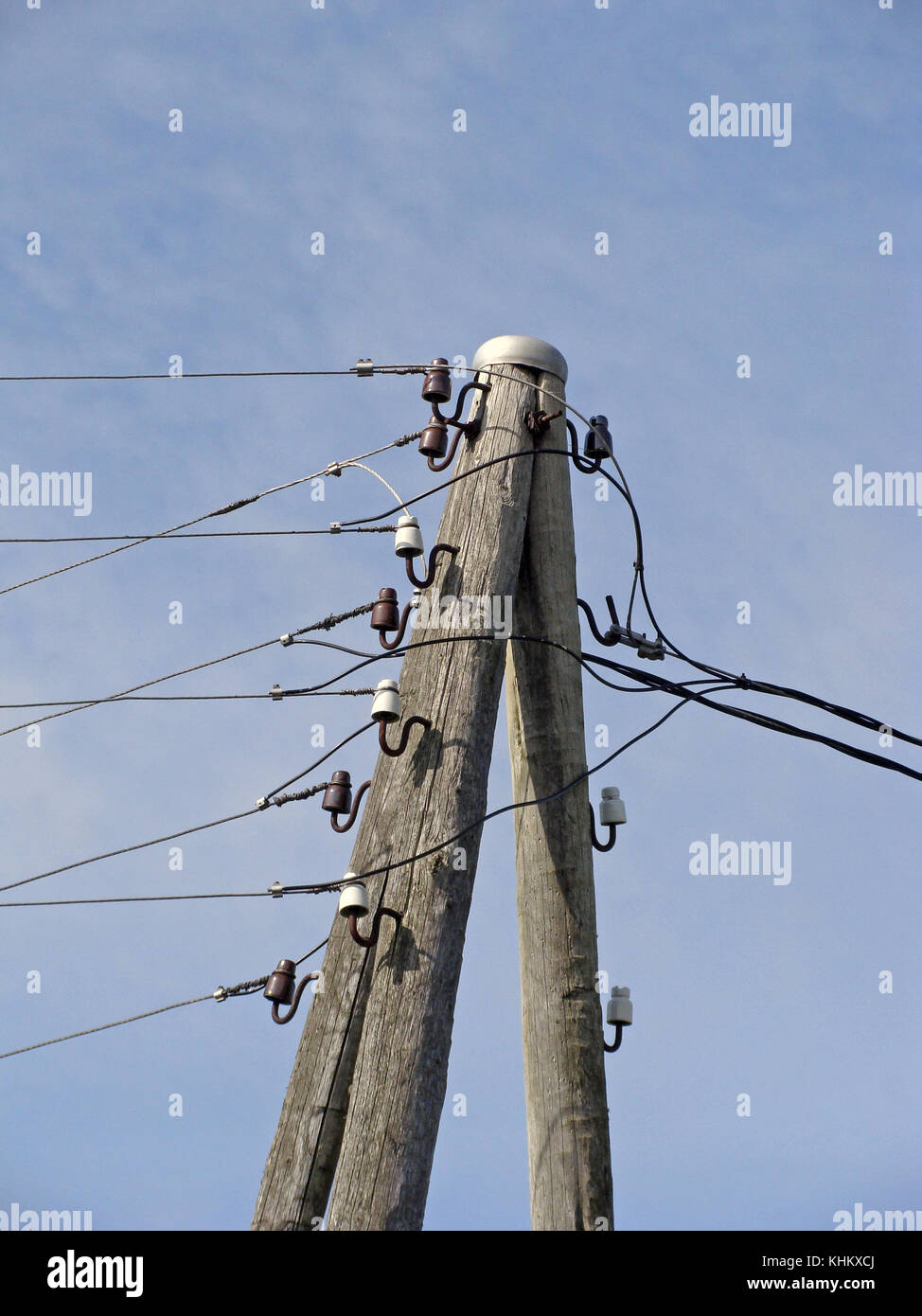 Top of old electric power line pole with wires and isolators connect to ...