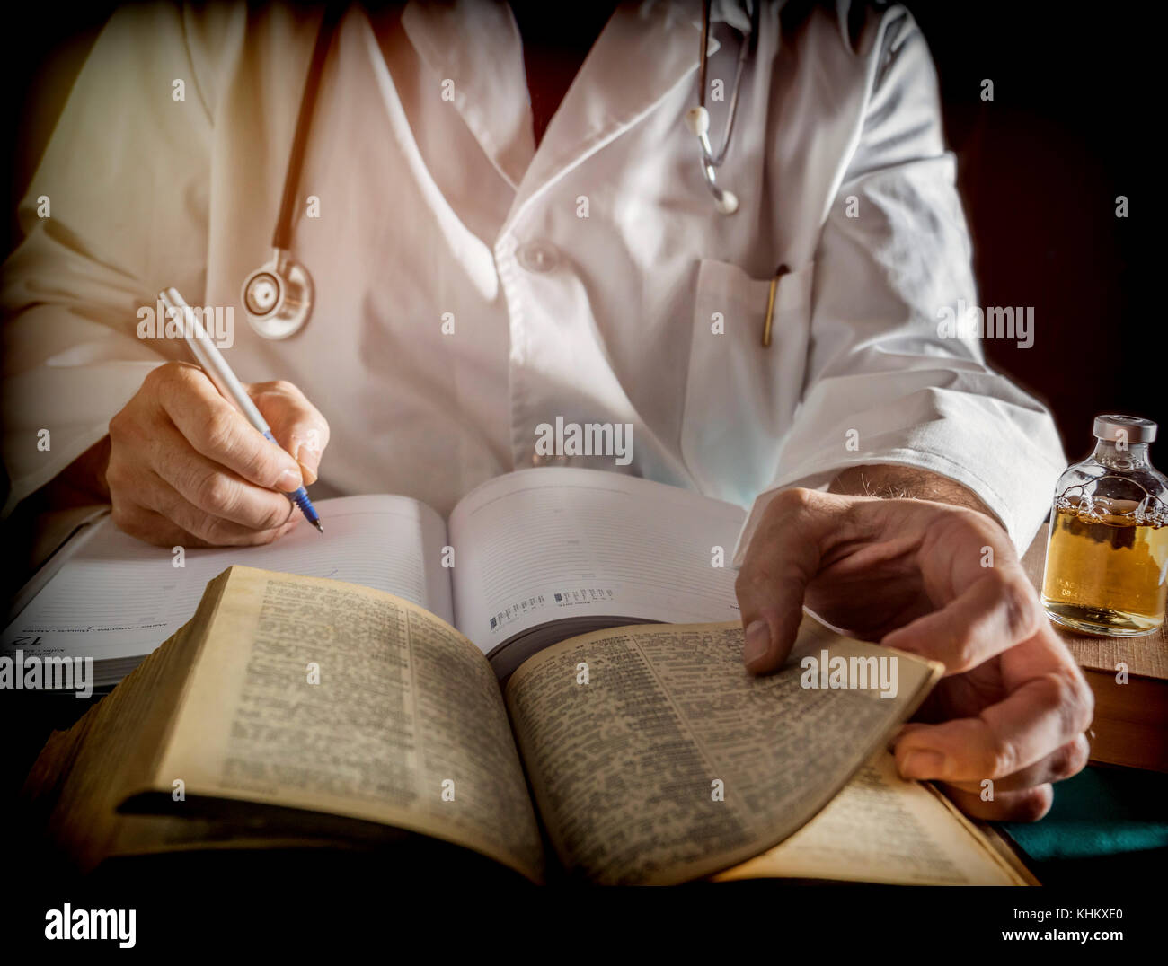 Doctor writes on a book of ancient medicine, conceptual image Stock ...