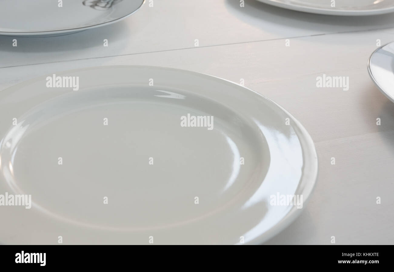 Modern empty plates on white background Stock Photo - Alamy