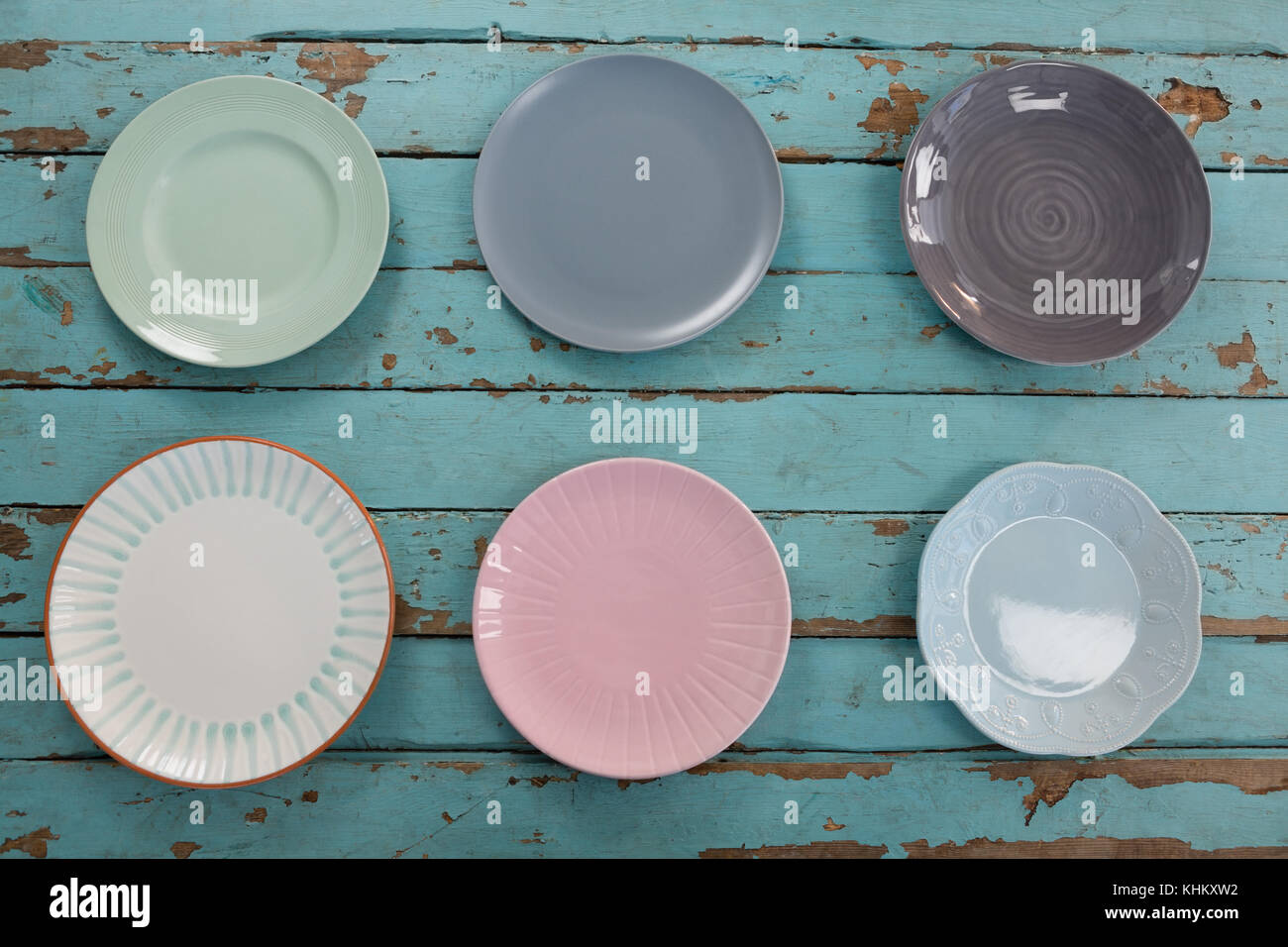 Various empty plates on wooden table Stock Photo - Alamy