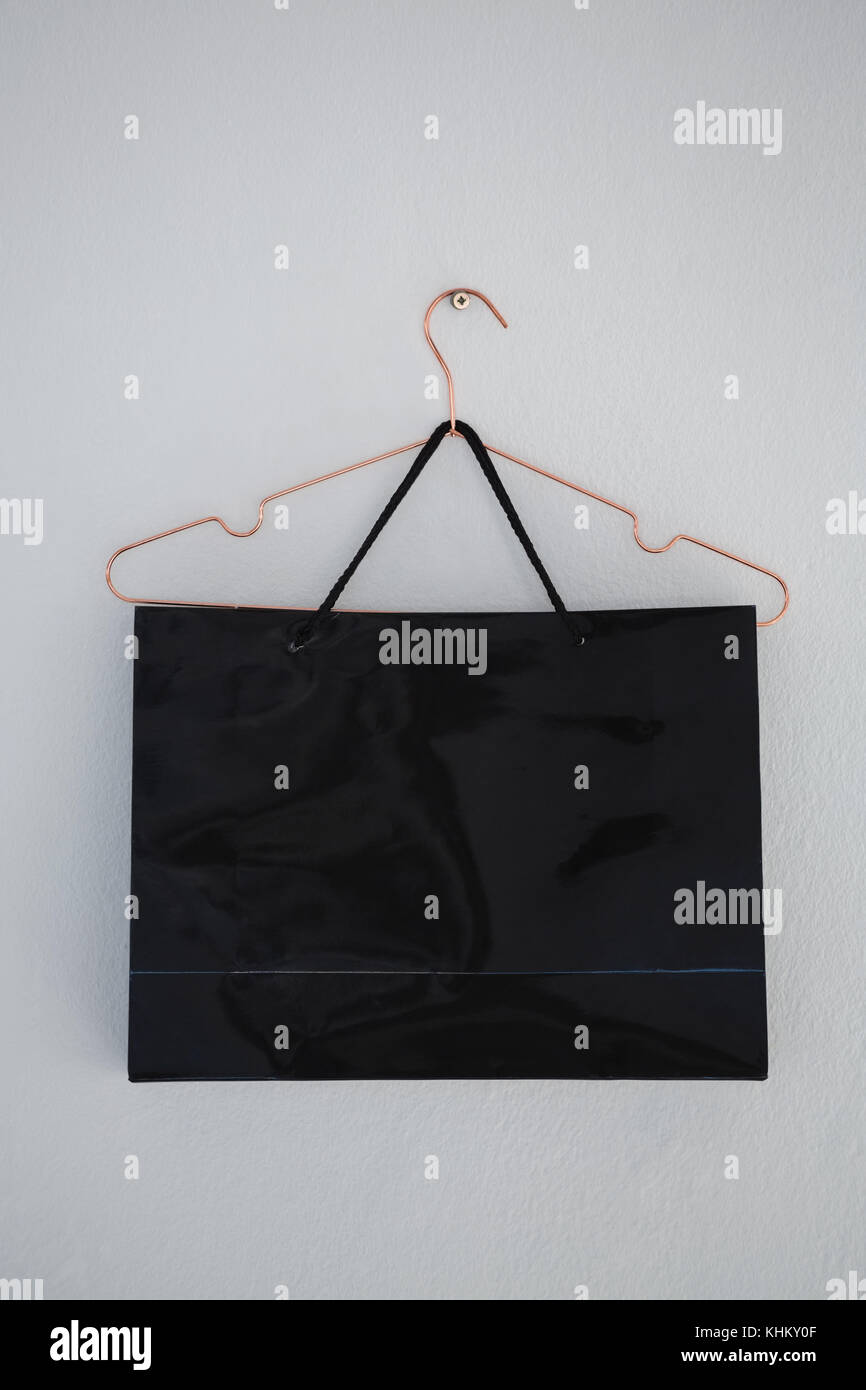 Close-up of shopping bag hanging on wall with hanger Stock Photo - Alamy
