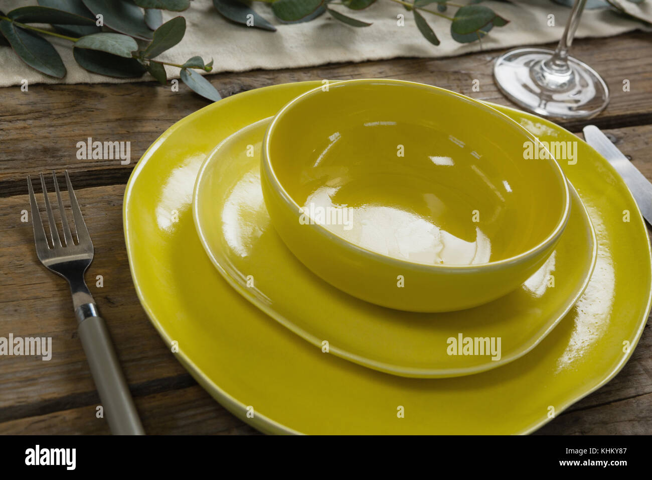 Stack of various dinnerware with cutlery on wooden table Stock Photo ...