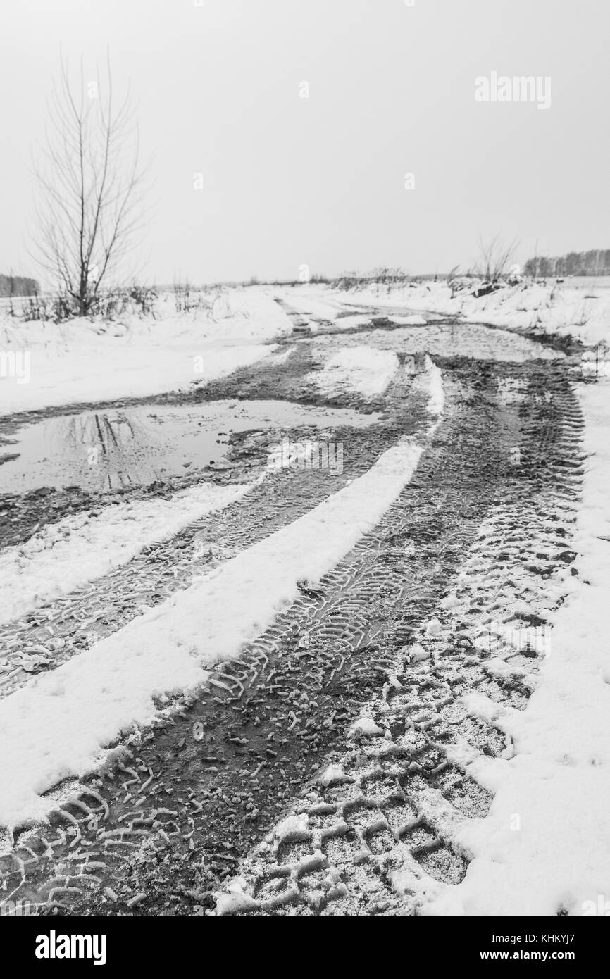 Traces of the tread of the car's wheels on the countryside snow-covered ...