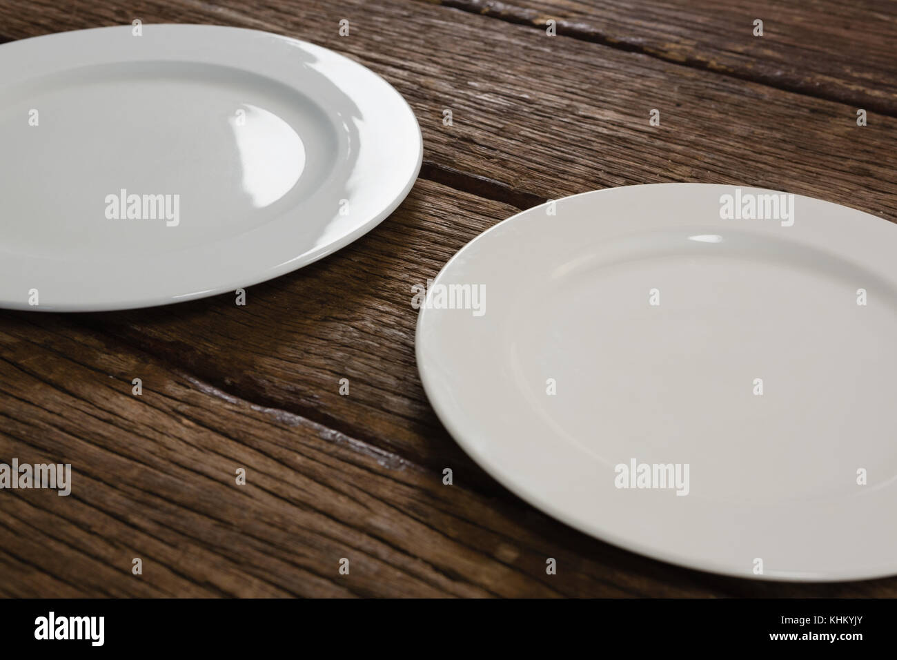 White empty plates on wooden table Stock Photo - Alamy
