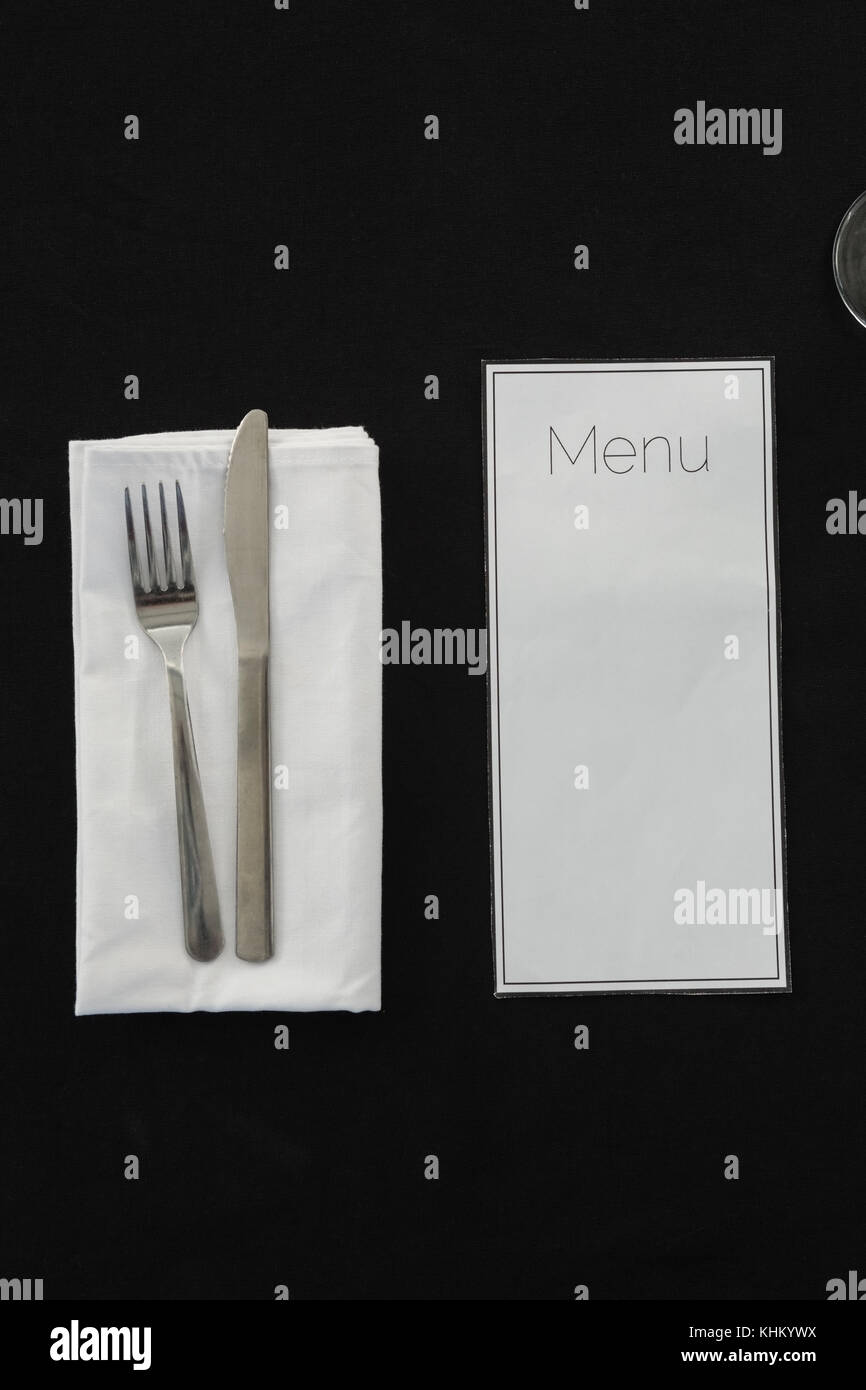 Black theme table setting with menu card Stock Photo - Alamy