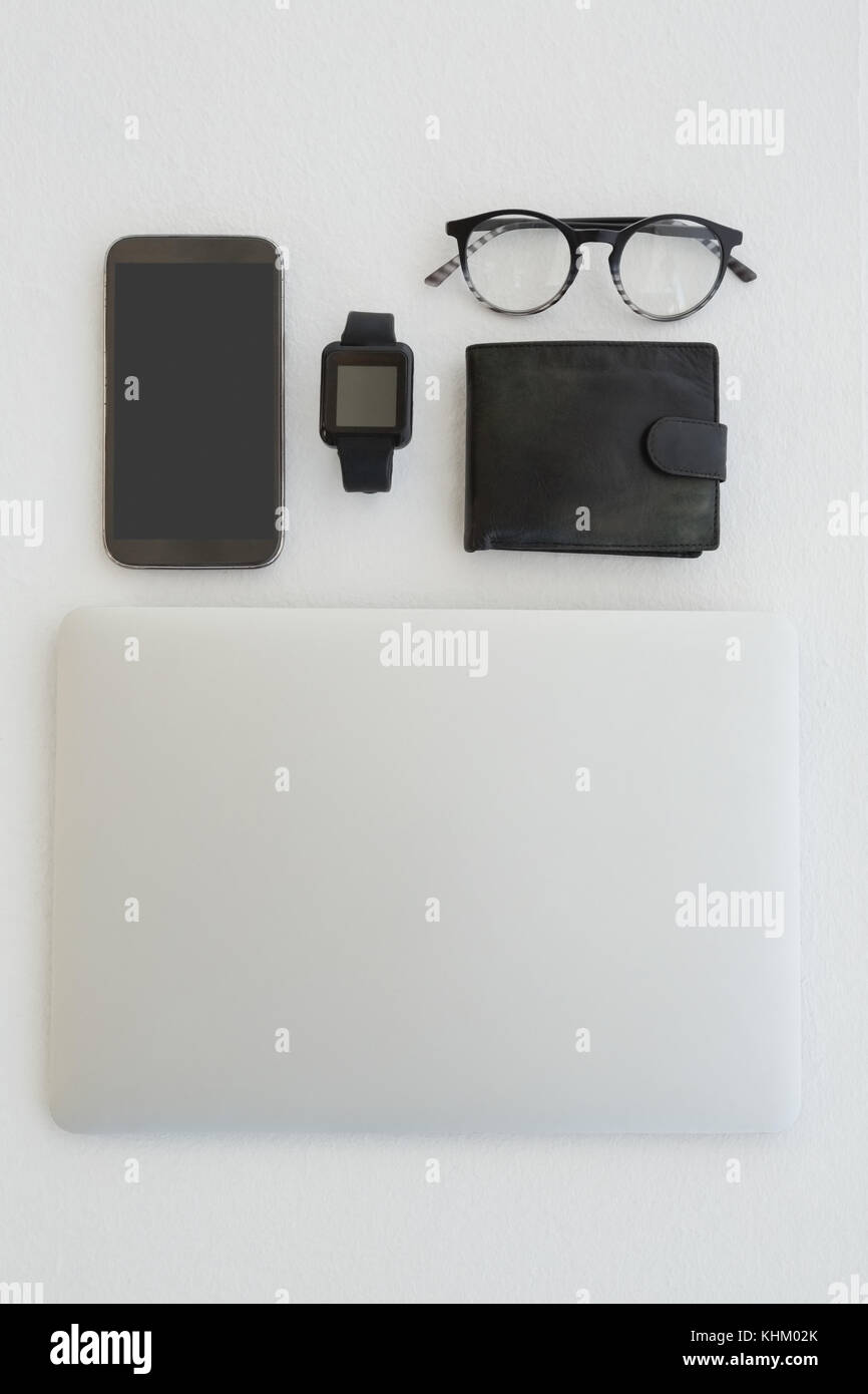 Overhead of various gadgets, spectacles and wallet on white background ...