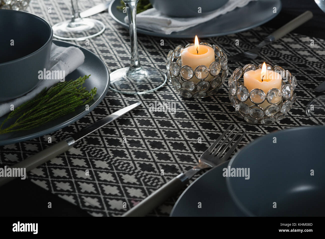 Elegance table setting with lit candle on table Stock Photo - Alamy