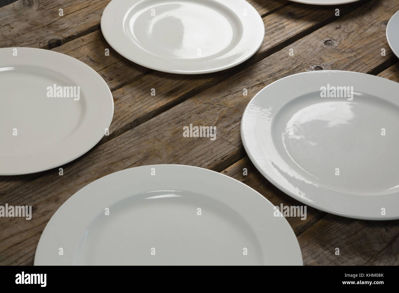 Close-up of empty plates on wooden plank Stock Photo - Alamy