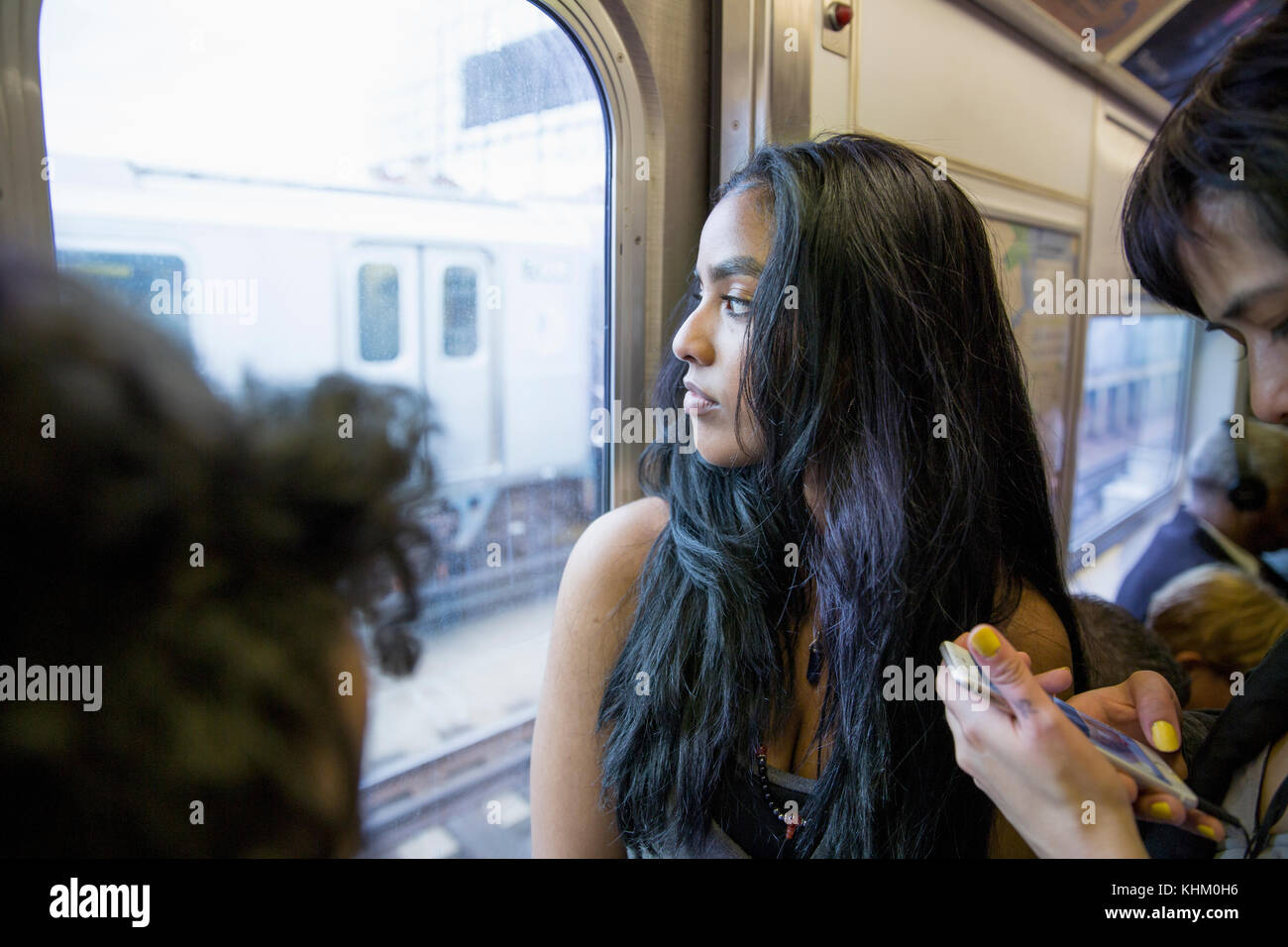 Young woman looking out the window of a train in Queens, New York Stock ...