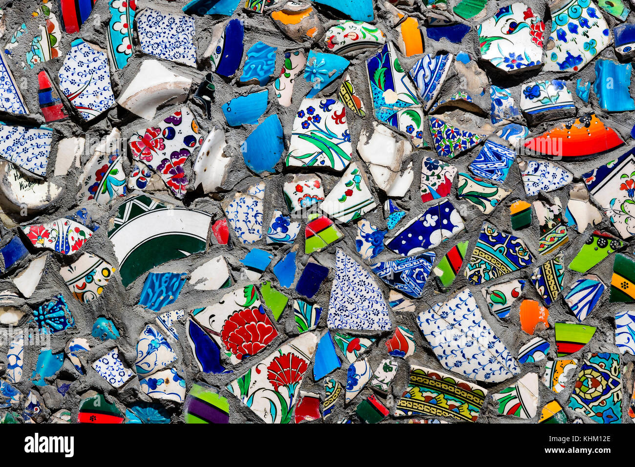 Wall with broken ceramic plates colored fragments Stock Photo - Alamy