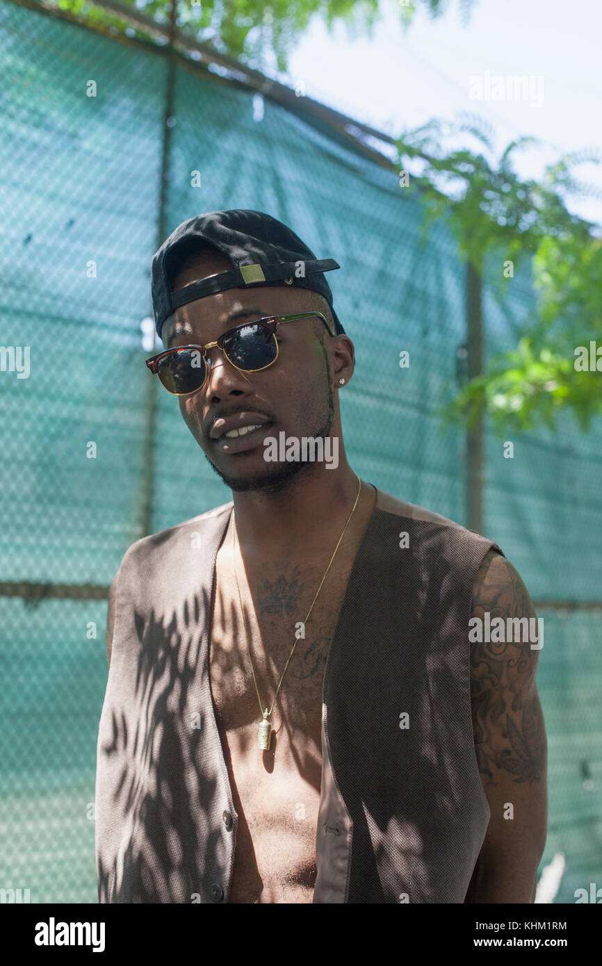 Young man wearing a baseball cap and sunglasses Stock Photo - Alamy