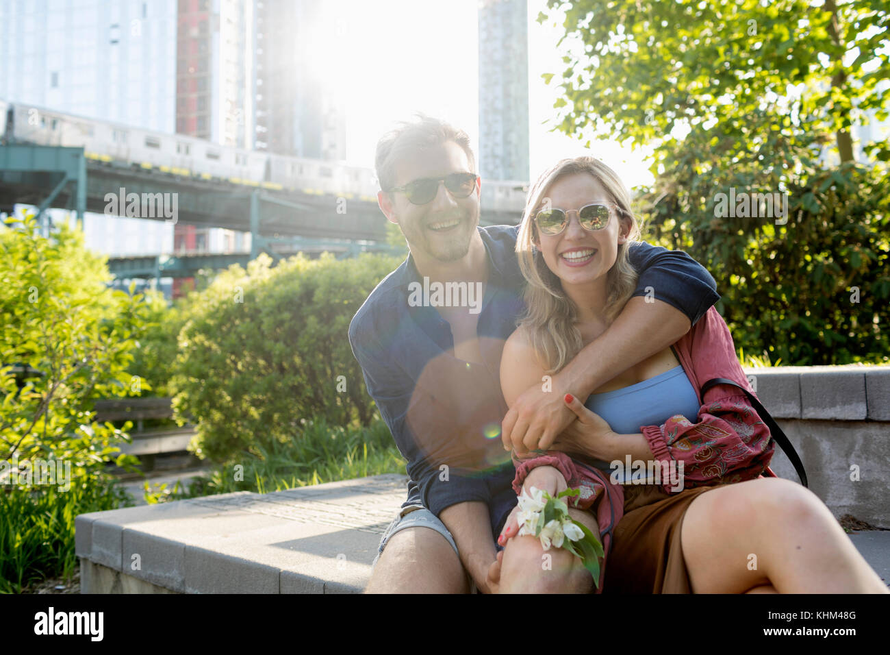 Couple sitting together in a park Stock Photo - Alamy