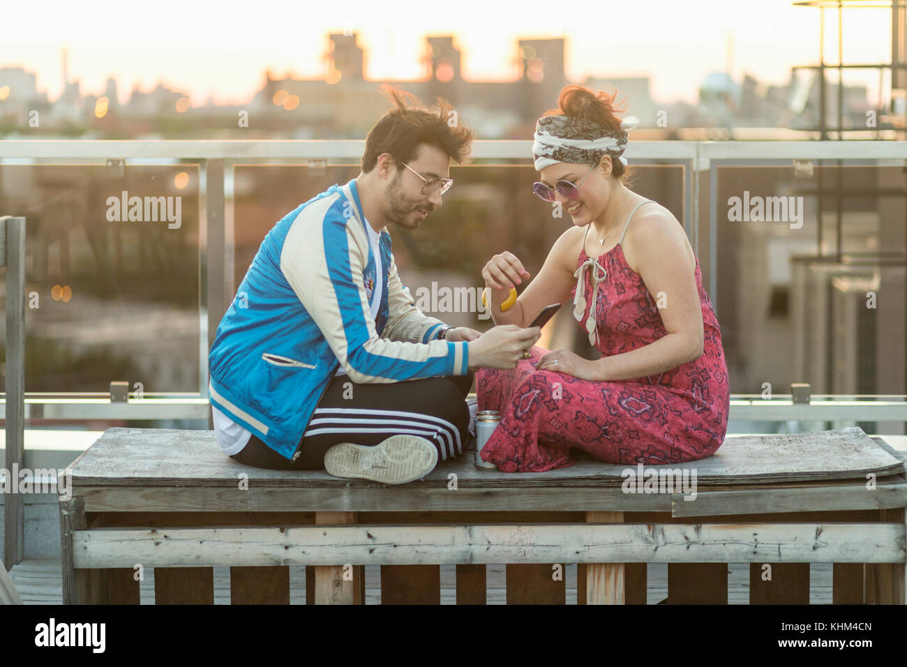 Friends sitting together on a rooftop Stock Photo - Alamy