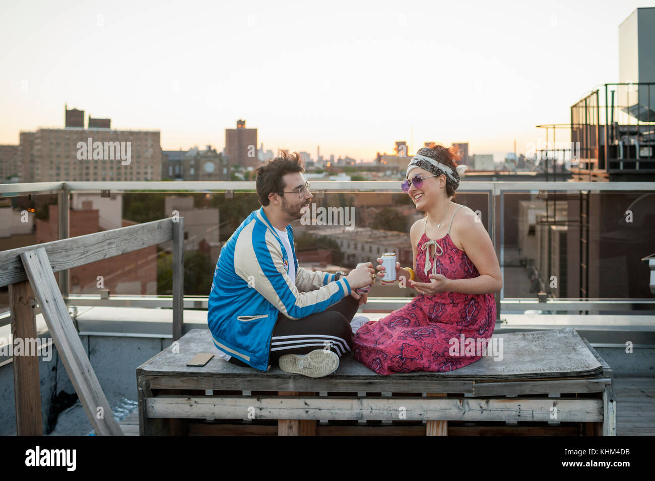 Friends sitting together on a rooftop Stock Photo - Alamy