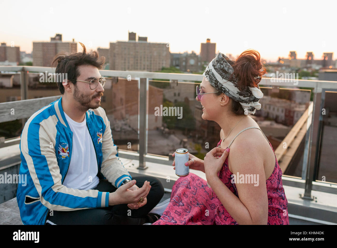 Friends sitting together on a rooftop Stock Photo - Alamy