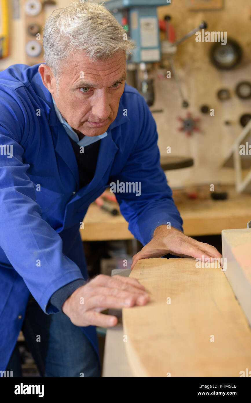 Senior man fitting piece of wood Stock Photo - Alamy