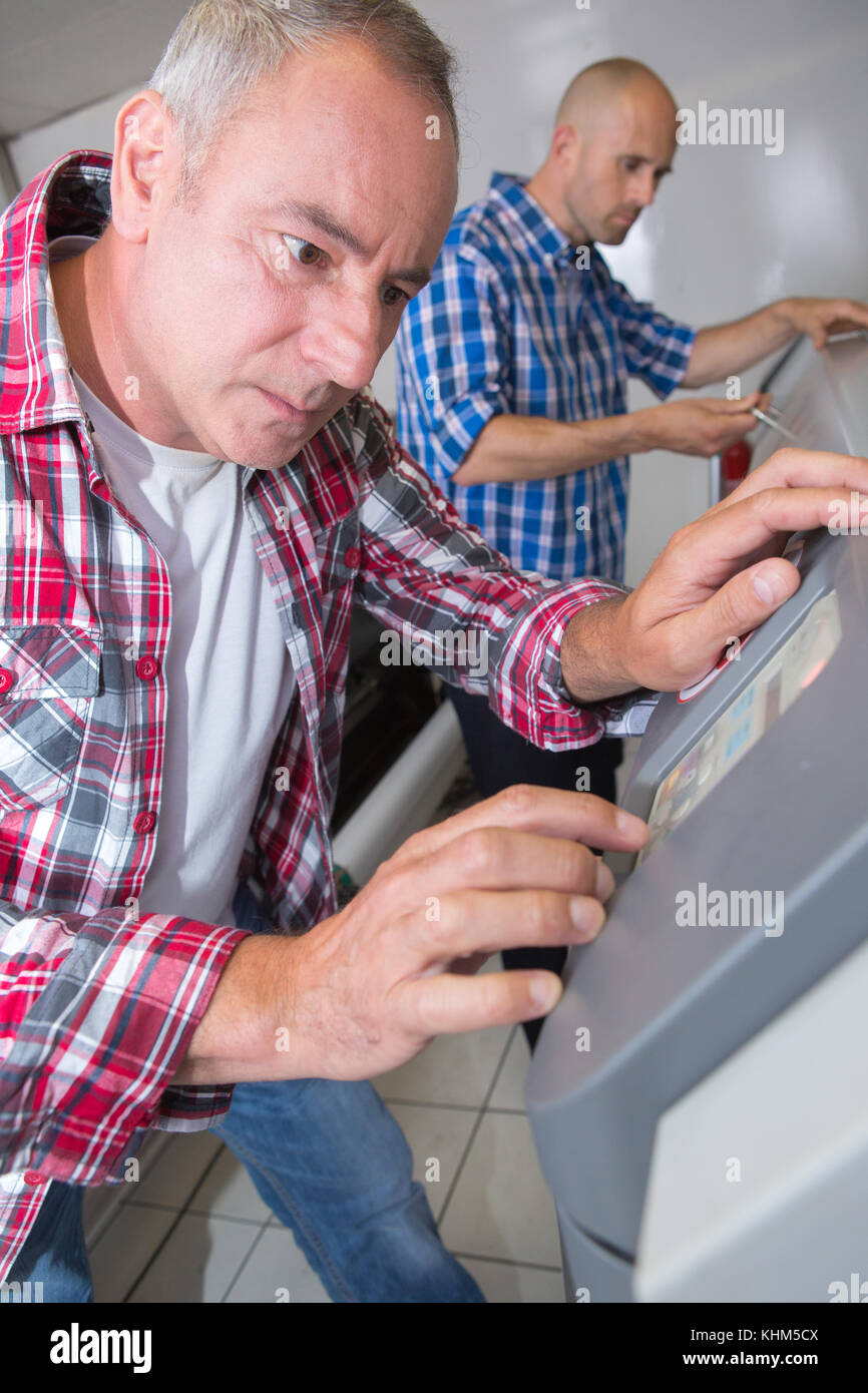 men using an office machine Stock Photo - Alamy