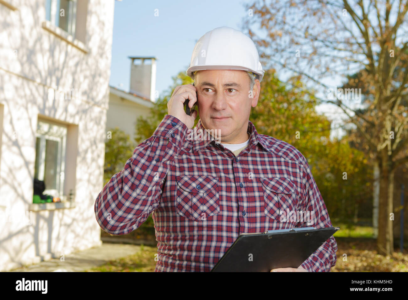 contractor holding the cost information and calling Stock Photo - Alamy