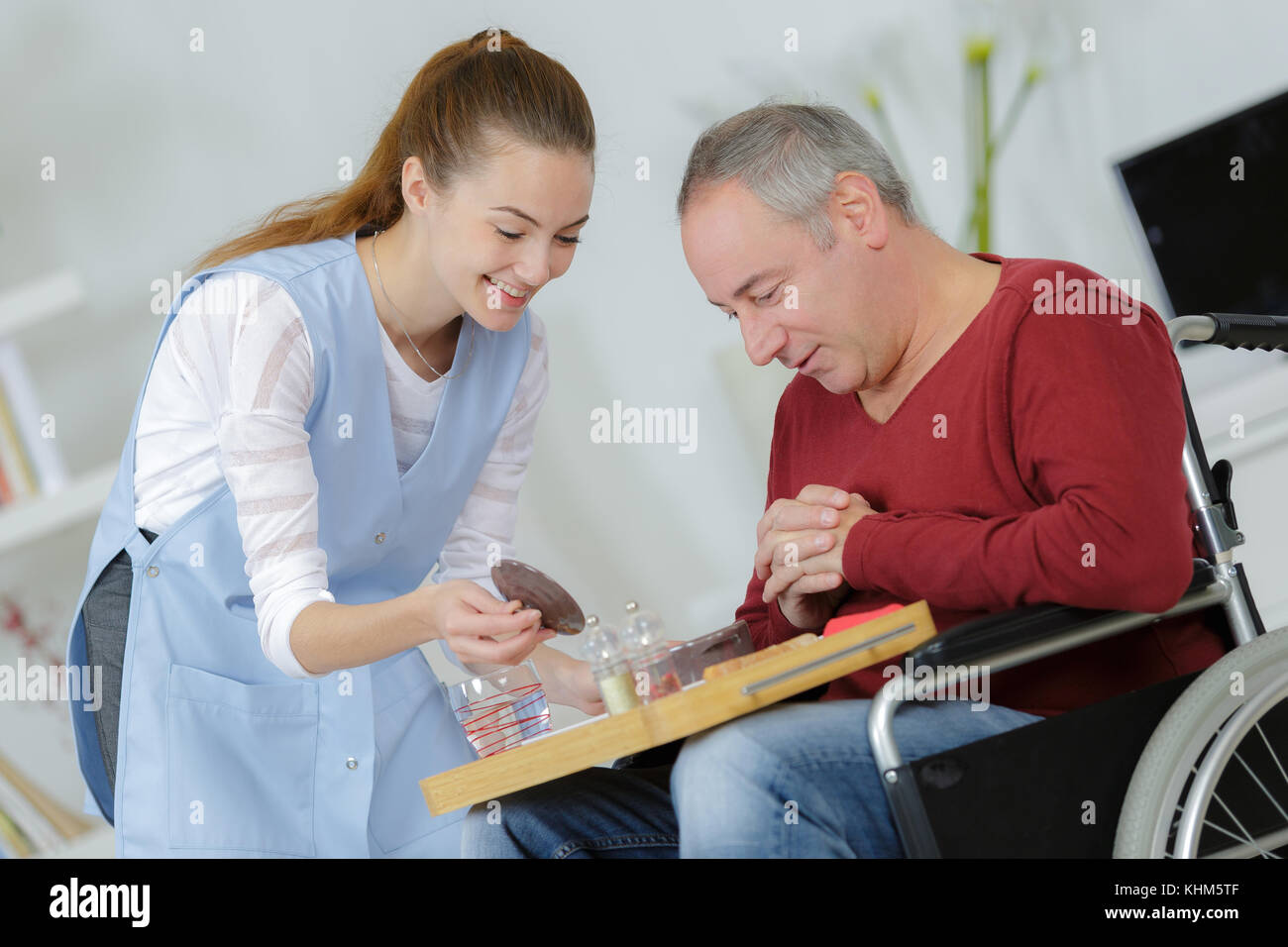 assistant helping man in wheelchair Stock Photo - Alamy