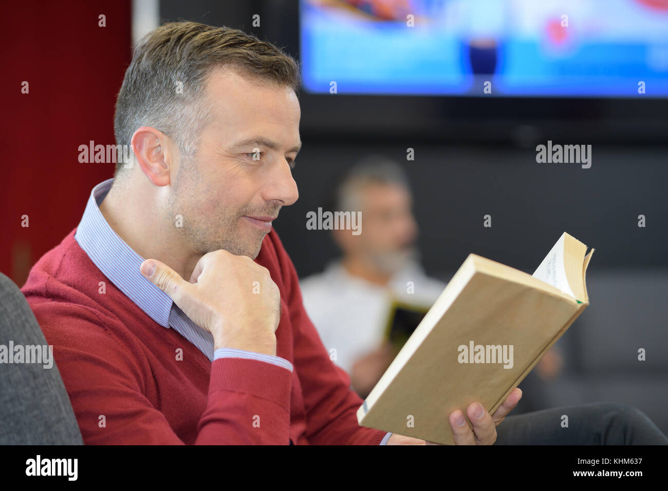 patient reading a book in doctors waiting room Stock Photo - Alamy