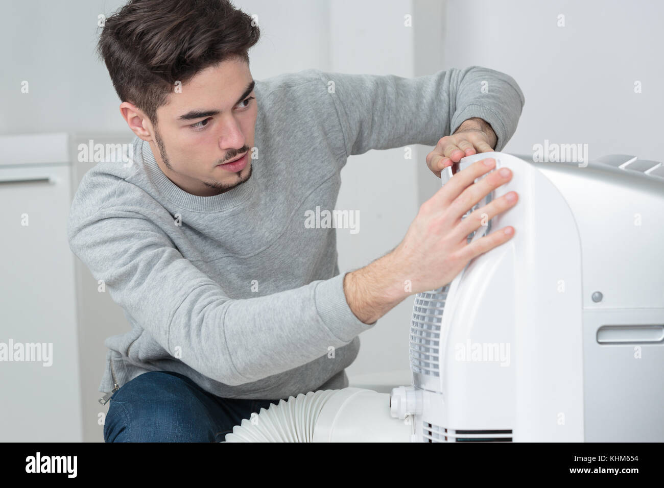 Man working on air conditioning unit Stock Photo - Alamy