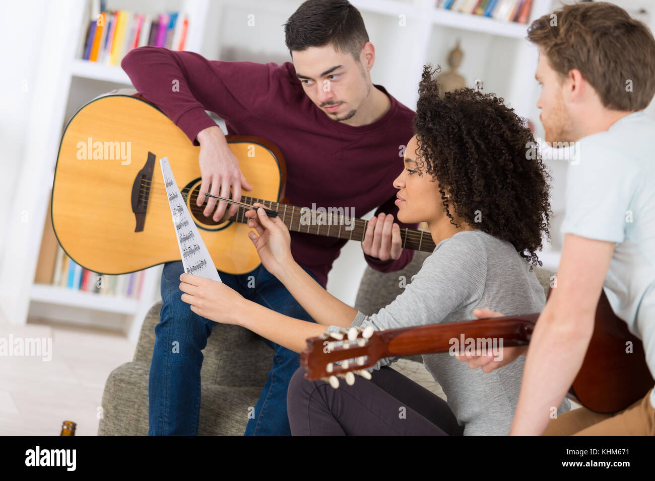 happy friends playing guitar and listening to music at home Stock Photo ...