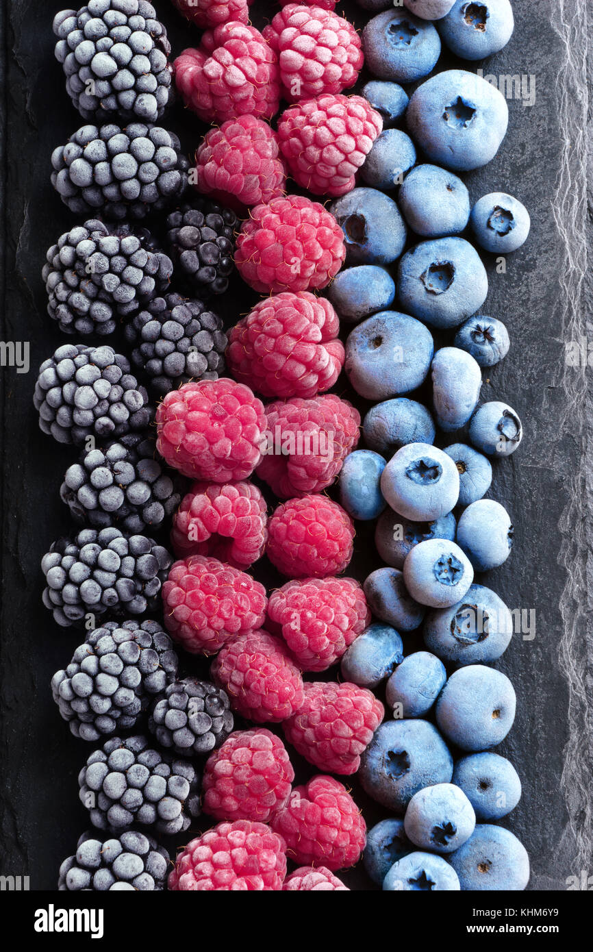 Frozen berries on black slate. Blueberry, raspberry, blackberry. Top ...