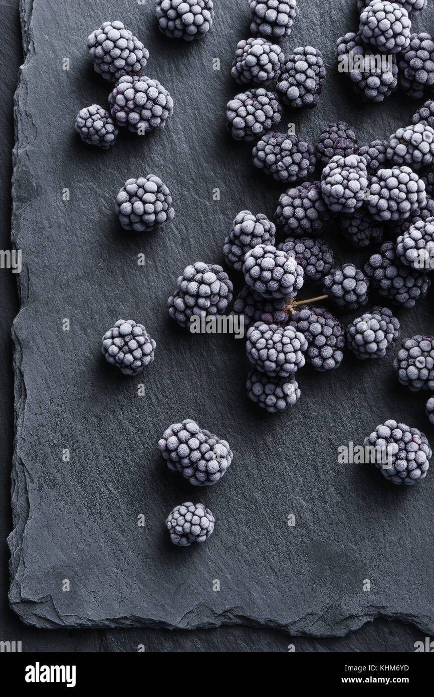 Frozen blackberry on black slate. Top view. High resolution product ...