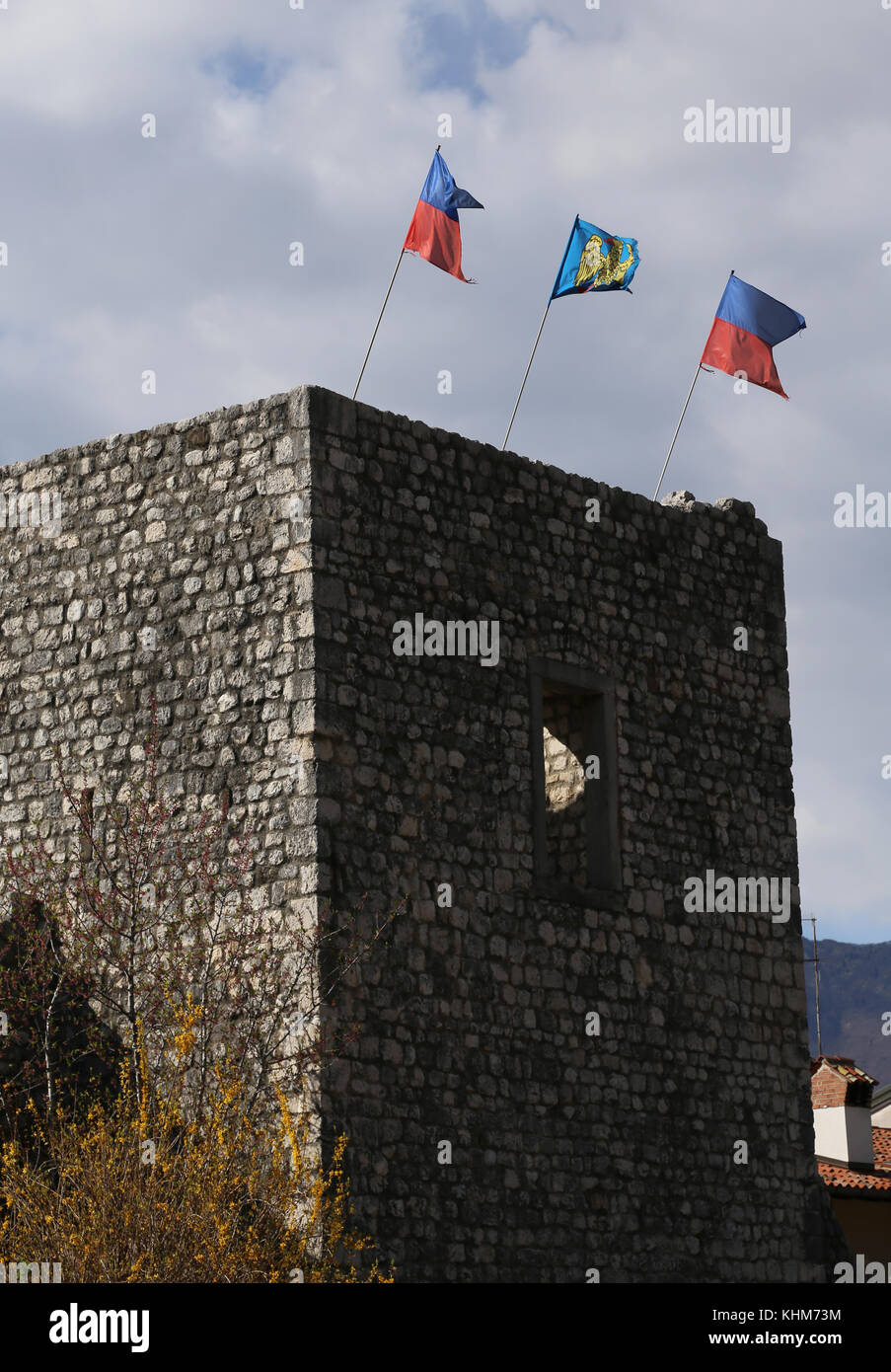 three flags on the ancient tower in the little town of Venzone in ...