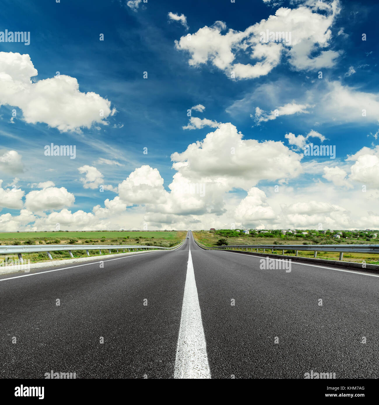 black asphalt road with white line on center and dramatic sky over it ...