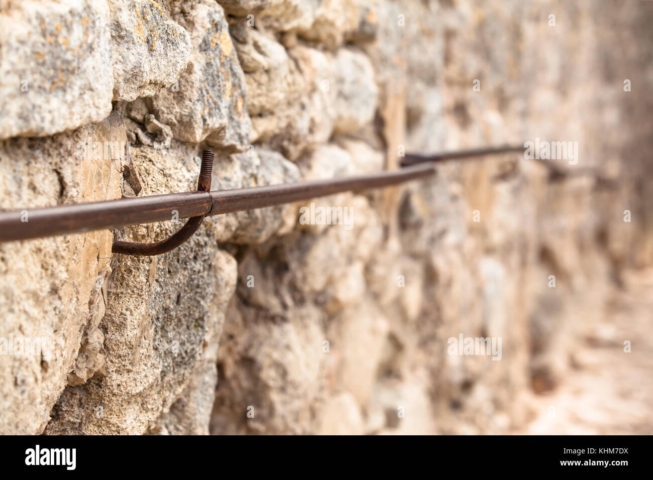 Old rusty handrail and mounting along stony natural wall in Provence ...