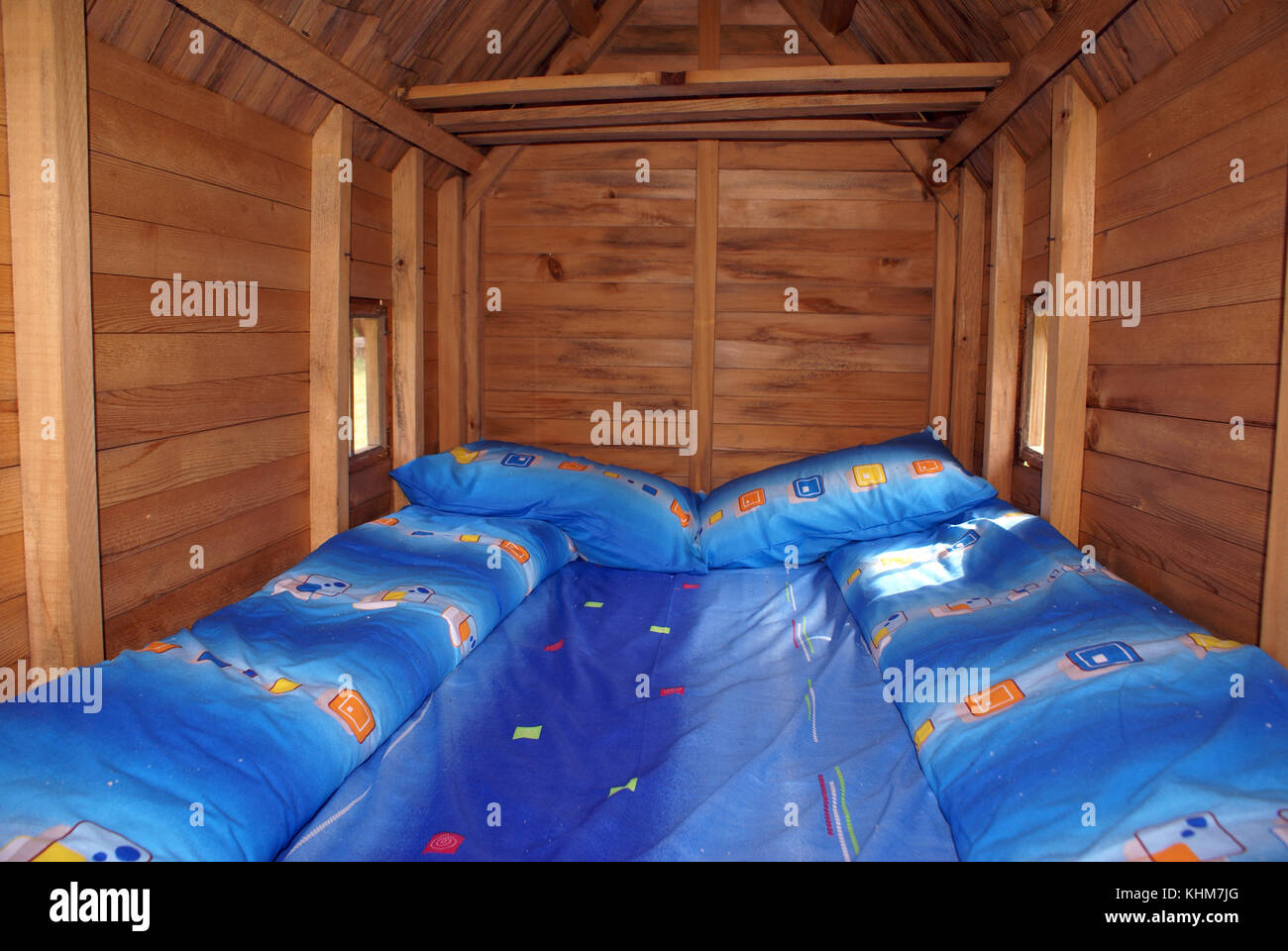 Bed inside wooden house Stock Photo - Alamy