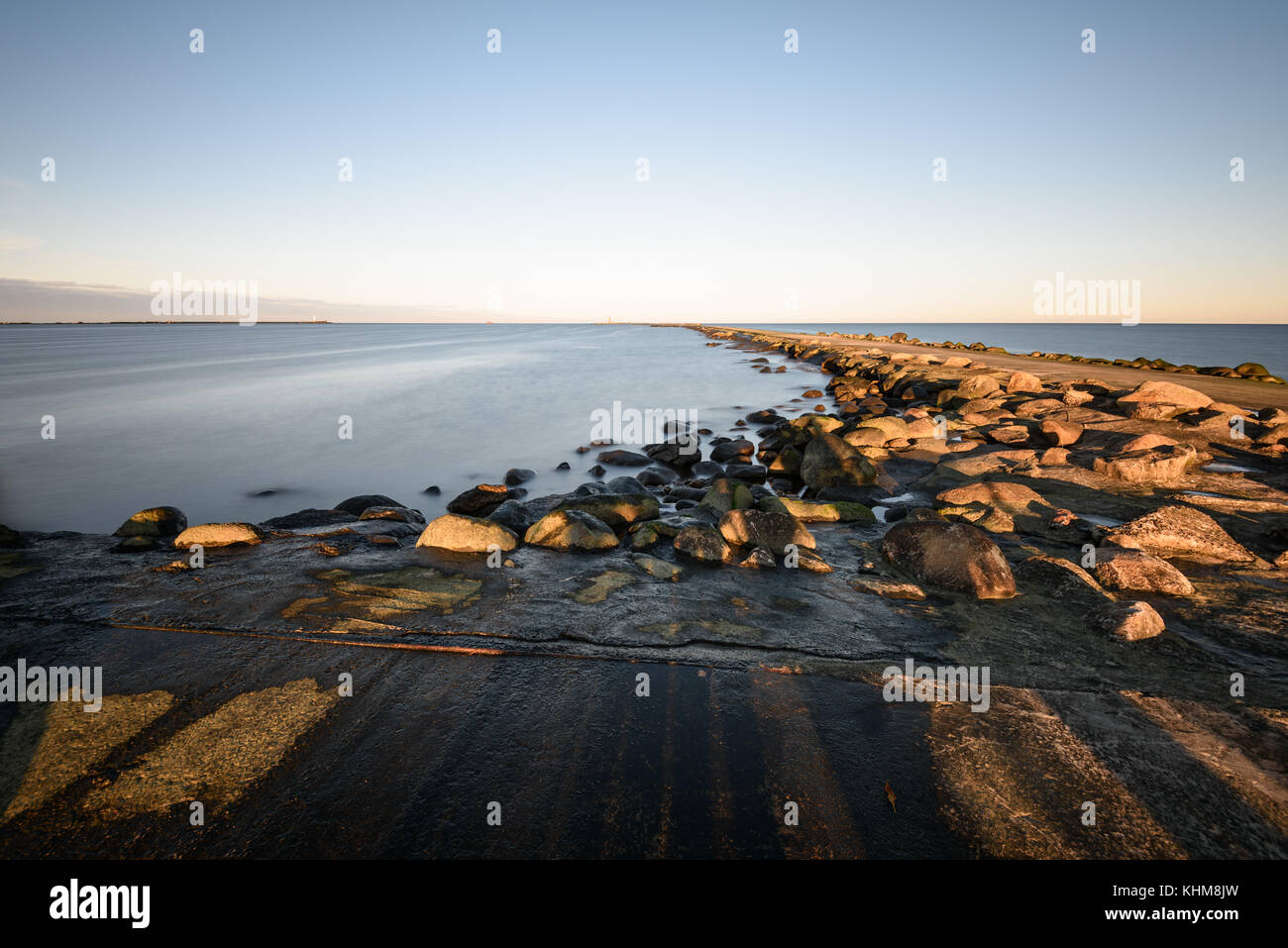 rocky sea beach with wide angle perspective over the sea with clouds ...