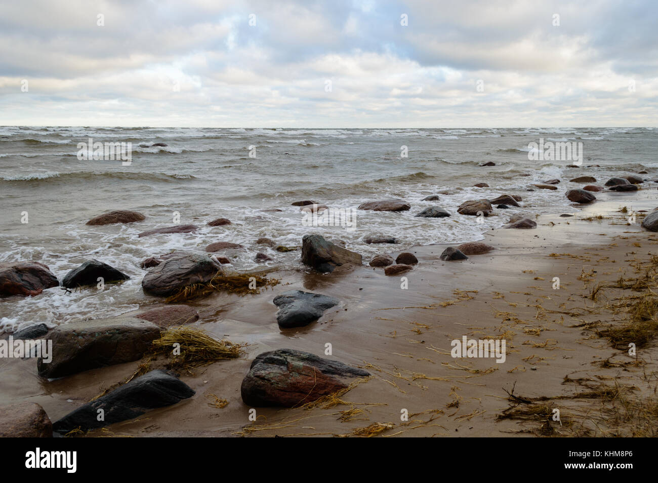 rocky sea beach with wide angle perspective over the sea with clouds ...