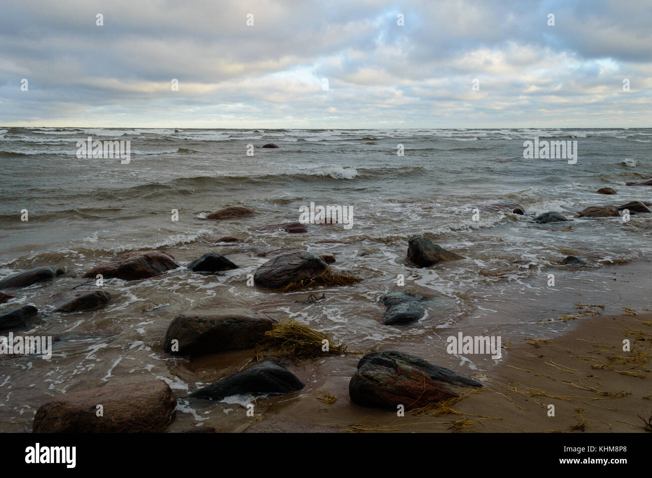 rocky sea beach with wide angle perspective over the sea with clouds ...
