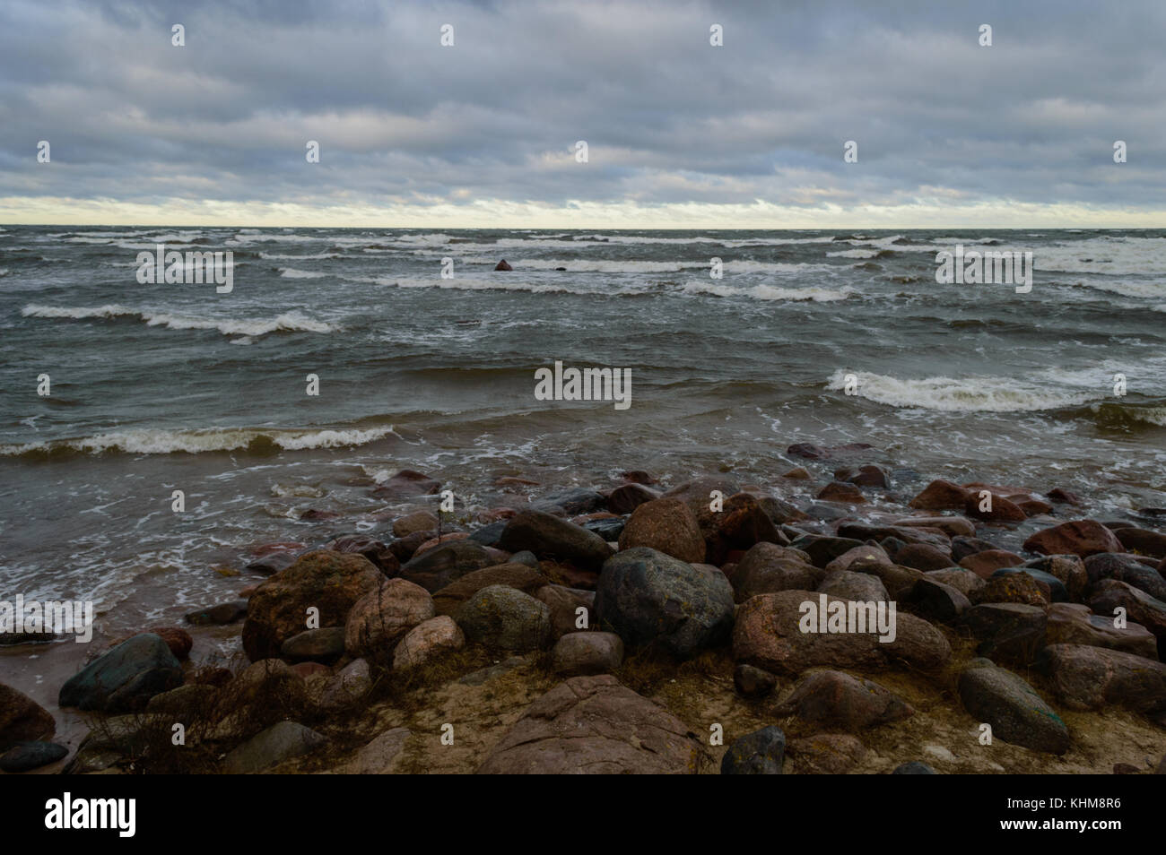 rocky sea beach with wide angle perspective over the sea with clouds ...