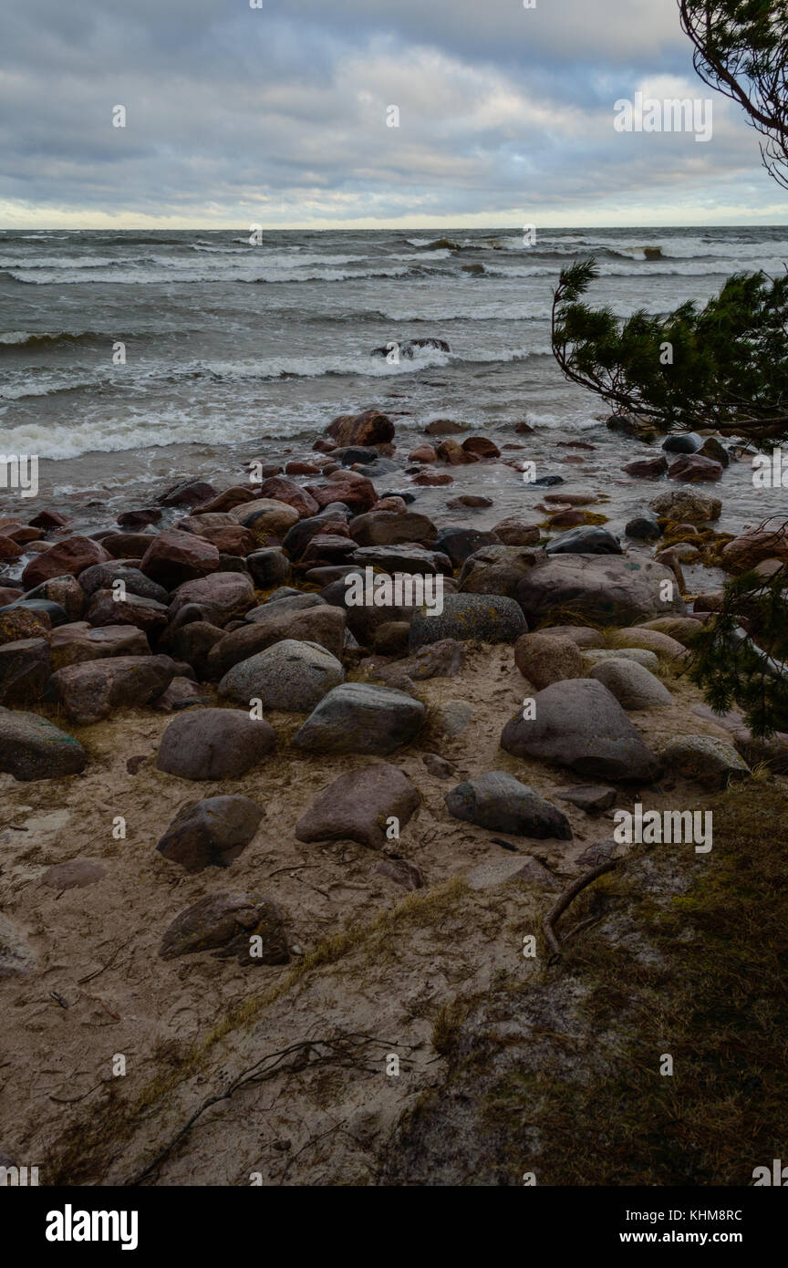 rocky sea beach with wide angle perspective over the sea with clouds ...