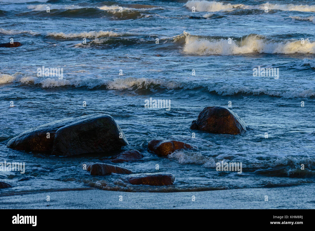 rocky sea beach with wide angle perspective over the sea with clouds ...