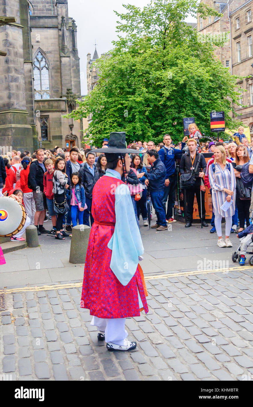 Male performer wearing a costume and using a fan to entertain an ...