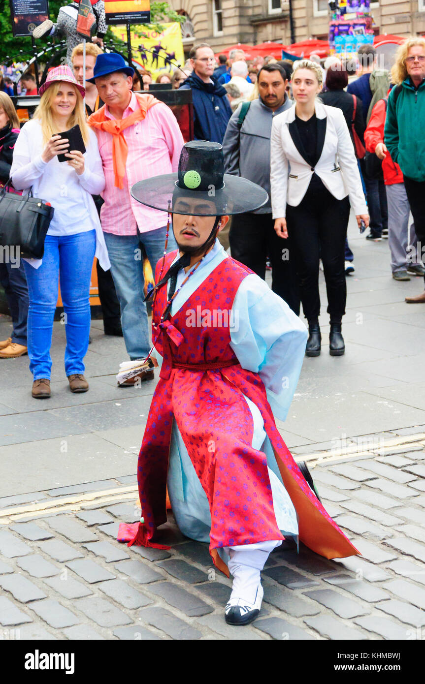 Male performer wearing a costume and using a fan to entertain an ...