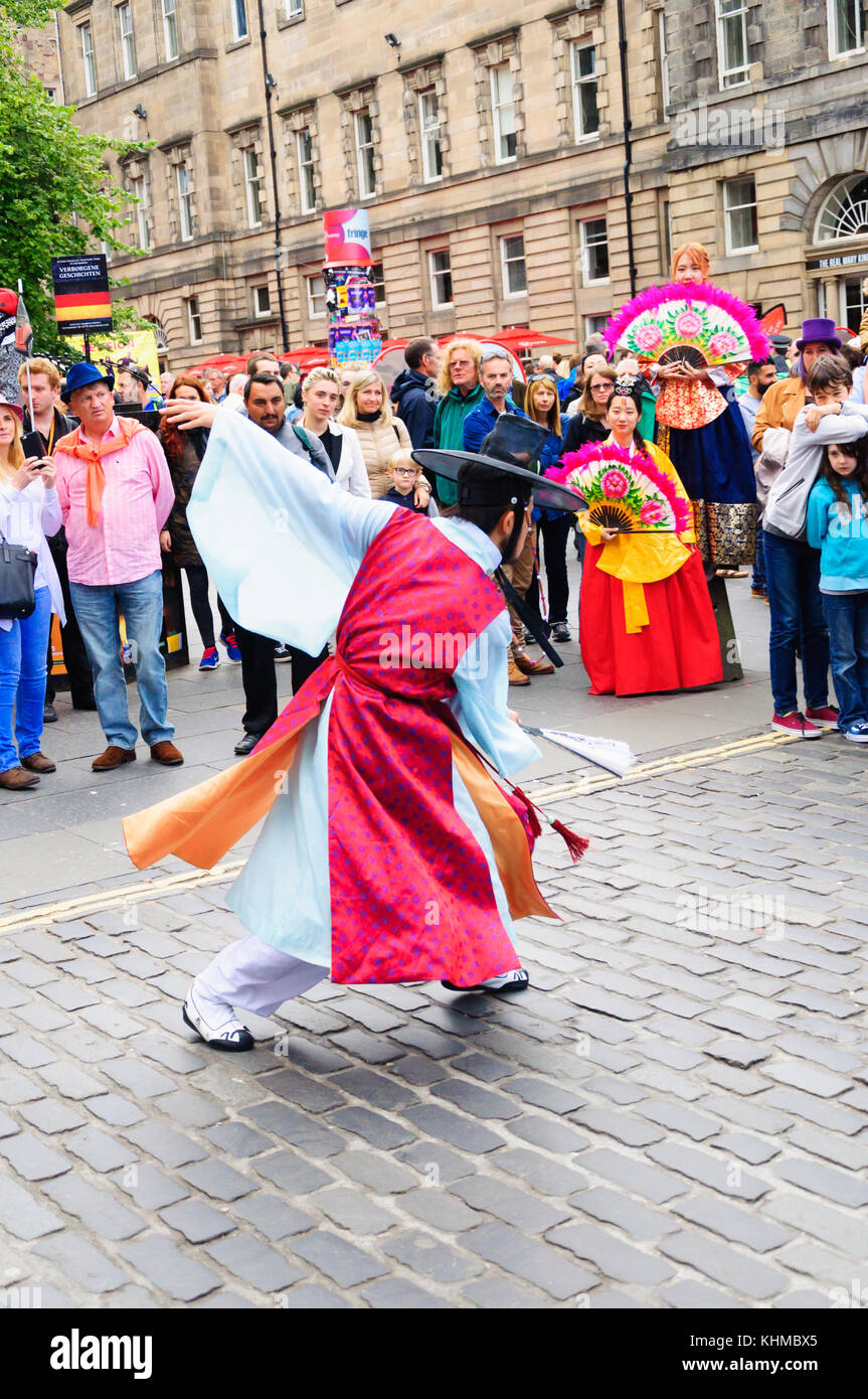 Male performer wearing a costume and using a fan to entertain an ...