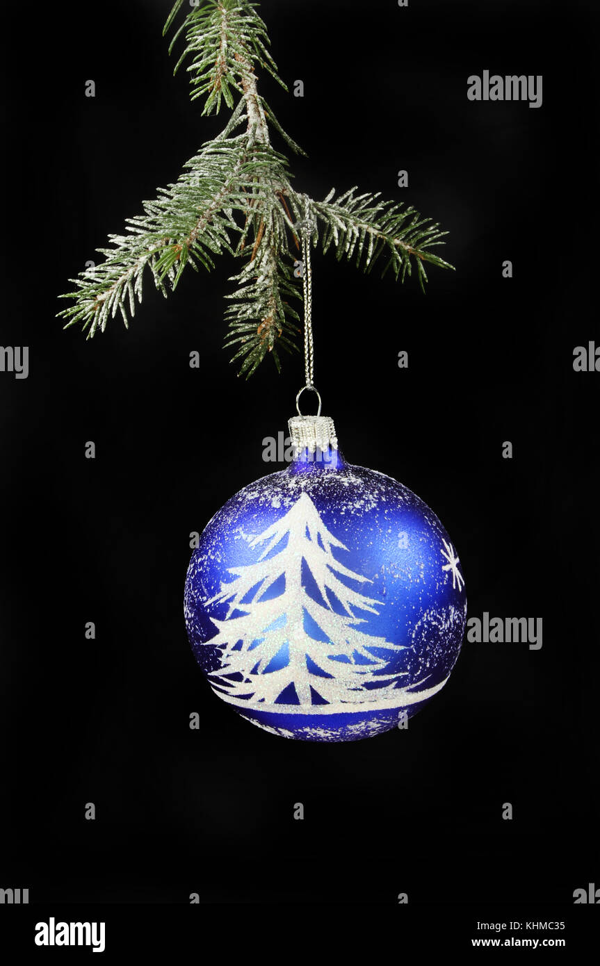 Snow scene Christmas bauble hanging from a snow dusted conifer branch ...