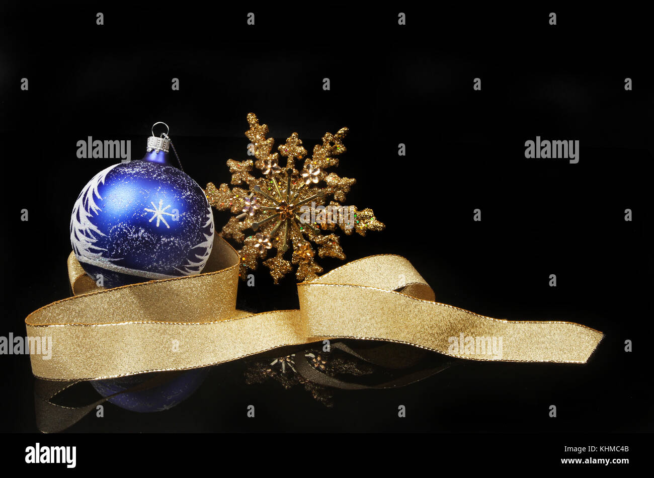 Christmas motif, snow scene bauble with a gold star and ribbon against ...