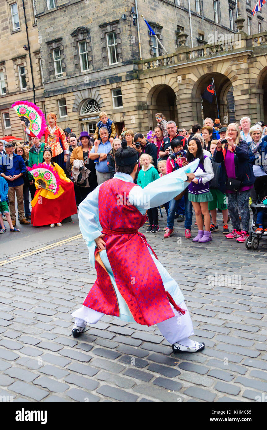 Male performer wearing a costume and using a fan to entertain an ...