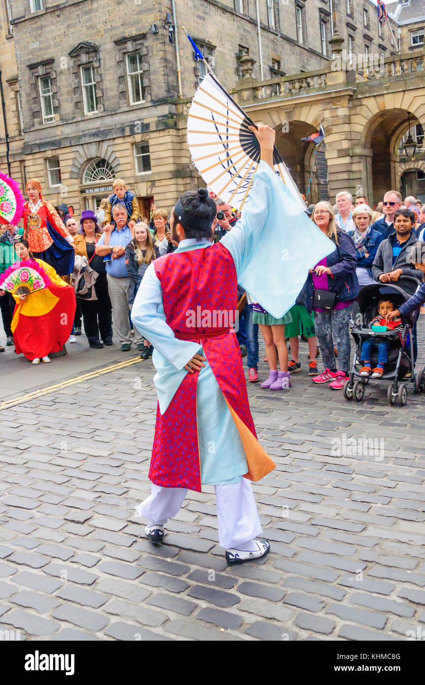 Male performer wearing a costume and using a fan to entertain an ...