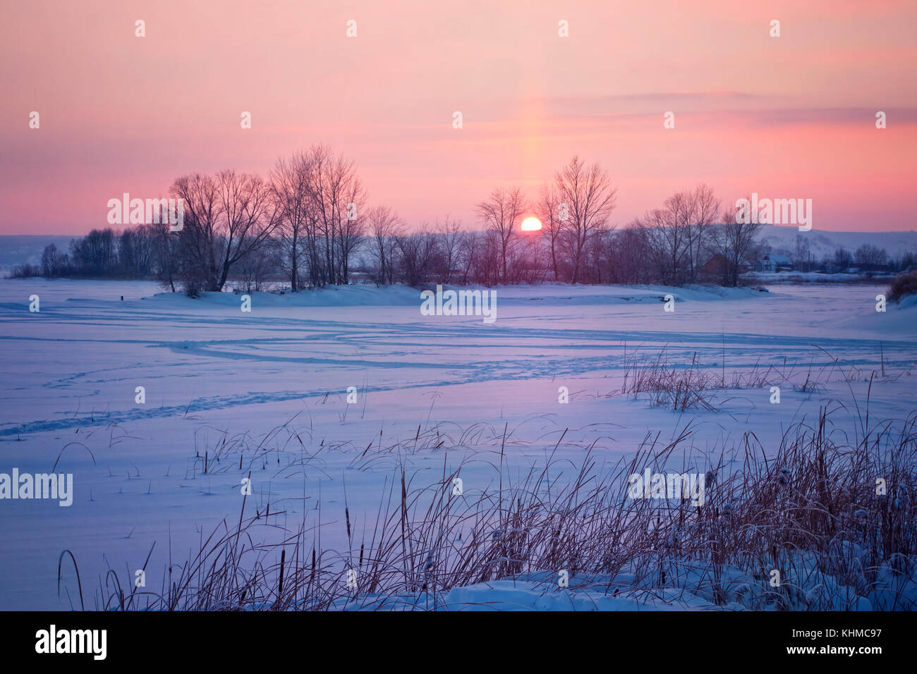 winter landscape image of river bank with reed and island at sunset ...
