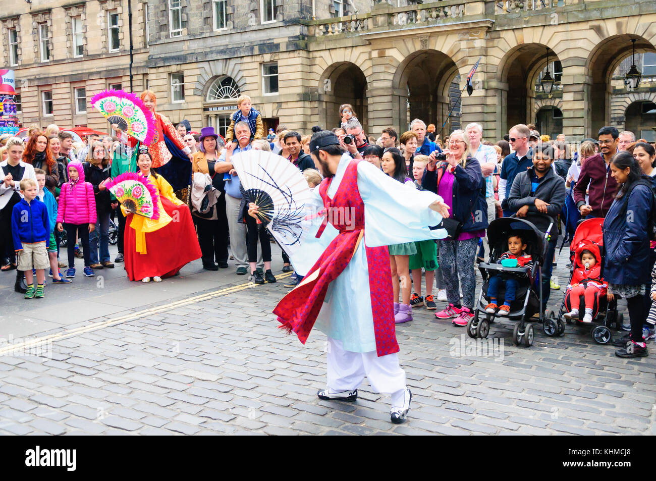 Male performer wearing a costume and using a fan to entertain an ...