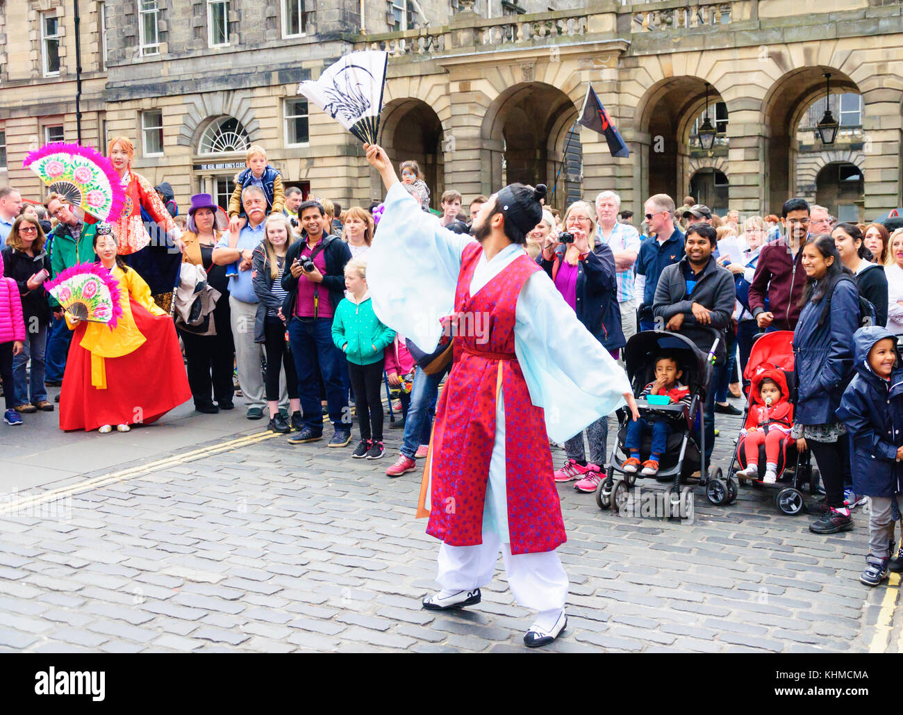 Male performer wearing a costume and using a fan to entertain an ...