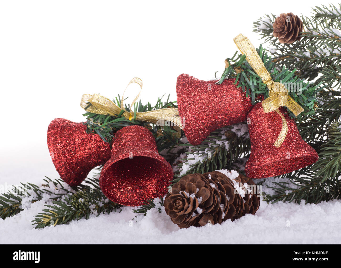 Red Christmas bells and evergreen tree branch on snow with white ...